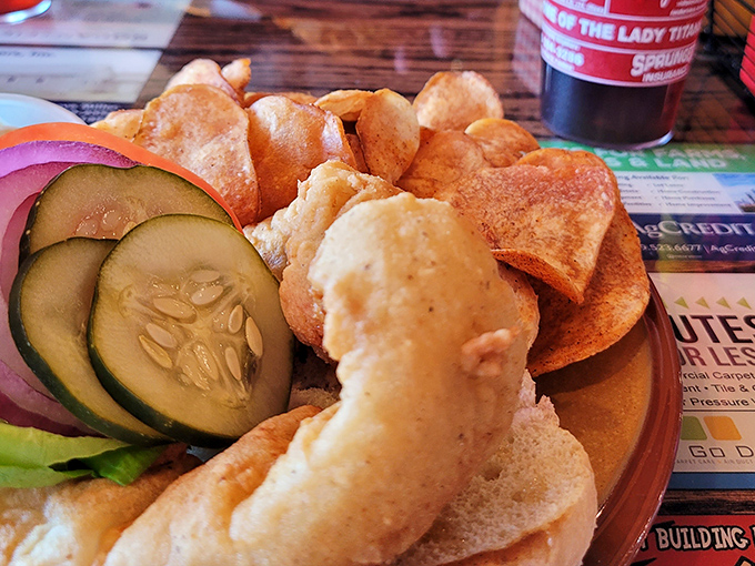 Crispy homemade chips, fresh veggies, and what appears to be a perfectly cooked piece of fish—proof that simple ingredients done right create magic.