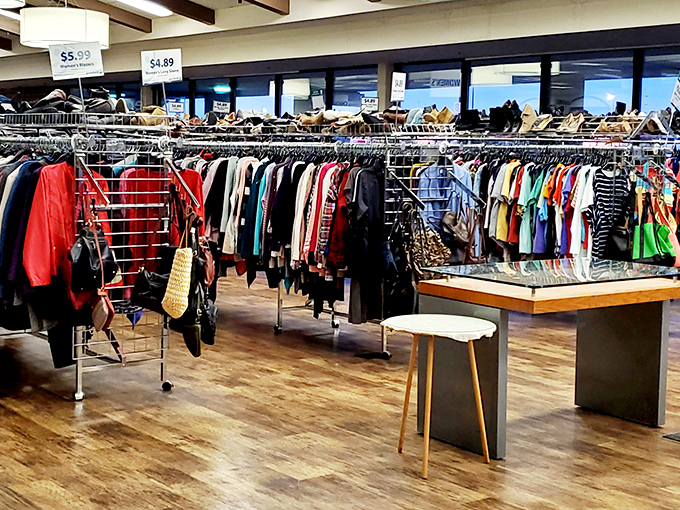 The women's section resembles a well-organized fashion time capsule. That coffee table in the foreground? Pure vintage elegance amid the clothing forest.