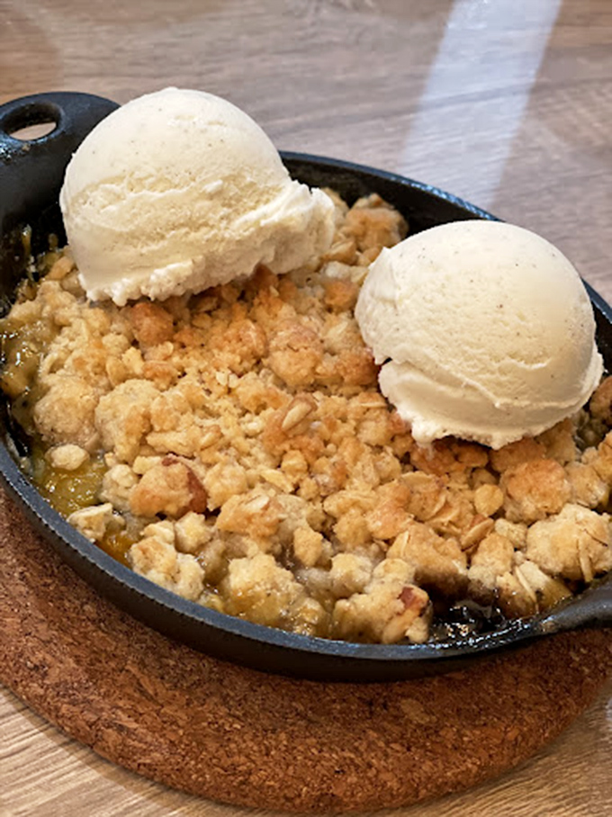 Apple crisp served in a cast-iron skillet with vanilla ice cream&mdash;proof that happiness is indeed a warm dessert.