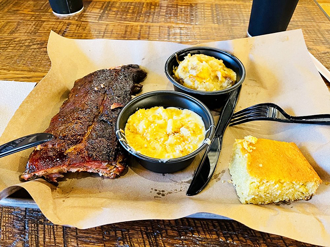 These ribs don't just fall off the bone—they practically leap onto your fork, flanked by golden mac and cheese and cornbread that's worth fighting over.
