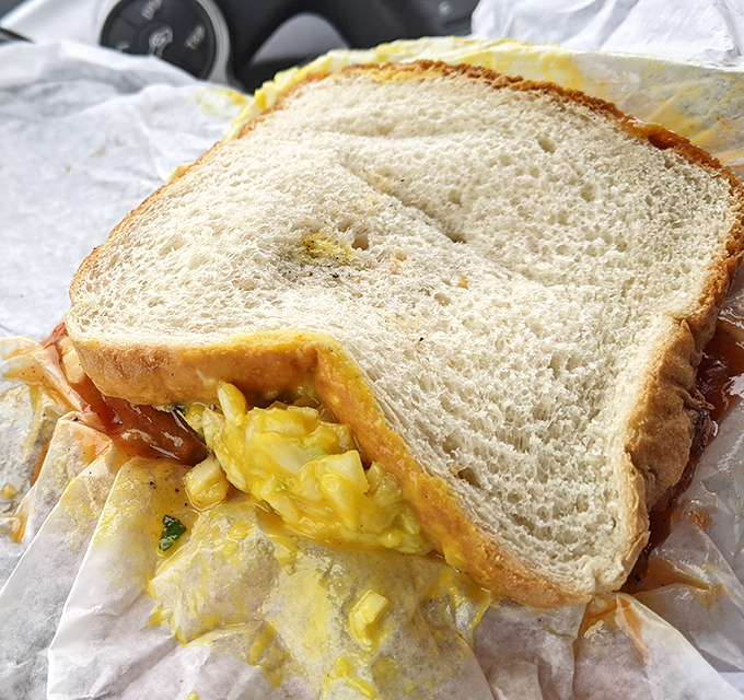 Not just any sandwich&mdash;layers of flavor architecture where bright mustard slaw meets smoky meat on a canvas of simple white bread.