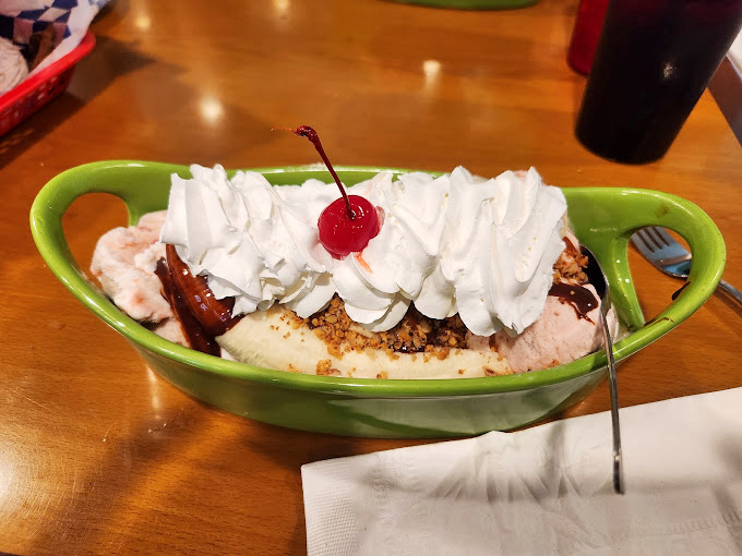 Ice cream dreams come true in this banana split, where whipped cream mountains and a cherry flag plant themselves in creamy territory.