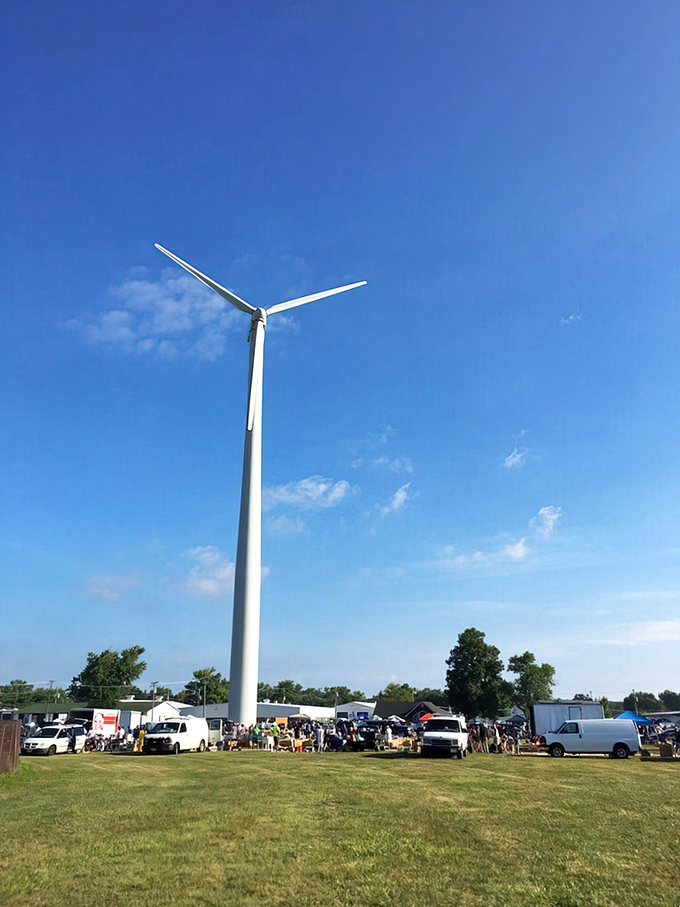 That wind turbine stands like a modern-day colossus, watching over treasure hunters as they scour tables for their next great find.