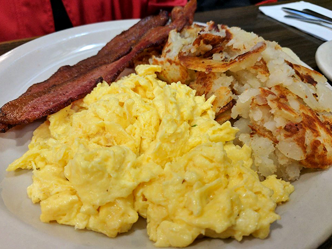 The breakfast trinity: perfectly scrambled eggs, bacon with just the right crispness, and those famous Country Way potatoes that could start their own fan club. 