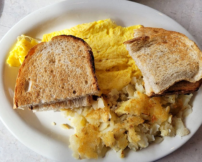 The breakfast plate that launched a thousand satisfied sighs. Golden toast, fluffy eggs, and home fries that make you wonder why you ever bother cooking at home.