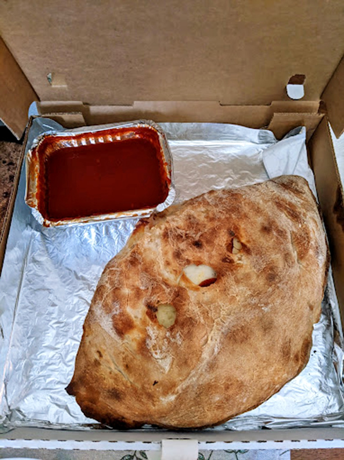 The calzone: pizza's introverted cousin that keeps all the good stuff on the inside. That sauce cup is about to become your best friend.