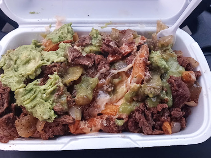 When fries become a main event. This mountain of carne asada, cheese, and guacamole transforms humble potatoes into a knife-and-fork adventure.