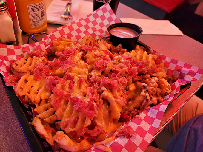 Waffle fries transformed into a cheese-covered masterpiece. The kind of appetizer that accidentally becomes your entire meal while no one's looking.
