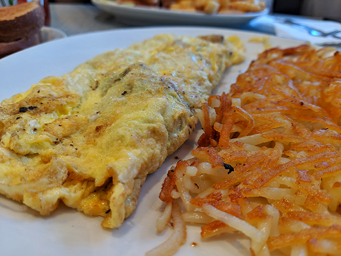 An omelet that doesn't need to name-drop fancy ingredients to impress, paired with hash browns crisped to mathematical perfection.