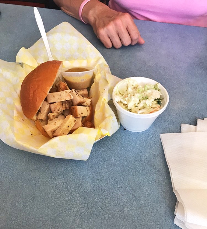 Sliced brisket served with no pretension, just pure BBQ integrity. The yellow-checkered paper is practically a warning sign: "Deliciousness Ahead!"
