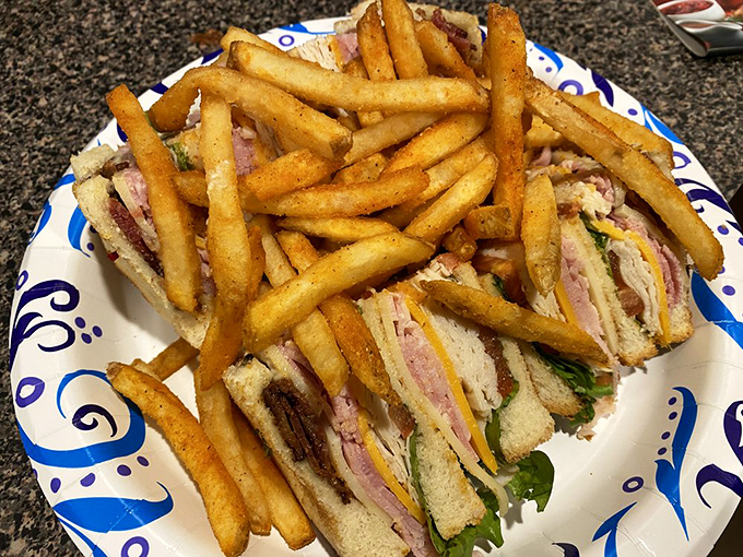 The club sandwich stands tall and proud, like the Eiffel Tower of lunch options. Those golden fries aren't sides&mdash;they're co-stars.