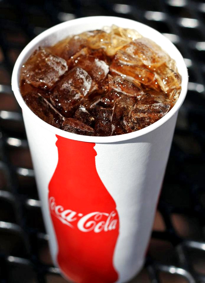 A classic Coca-Cola in a paper cup with ice&mdash;because sometimes the perfect accompaniment to sandwich perfection is refreshing simplicity. 