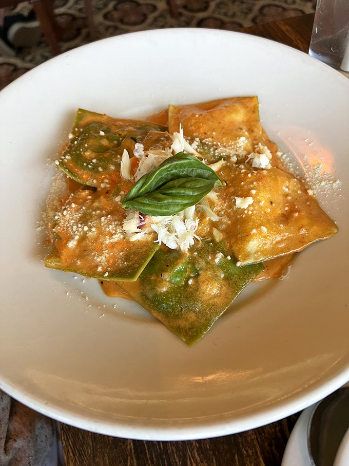 These ravioli pillows cradle secrets of the sea, topped with fresh basil like a chef's signature.