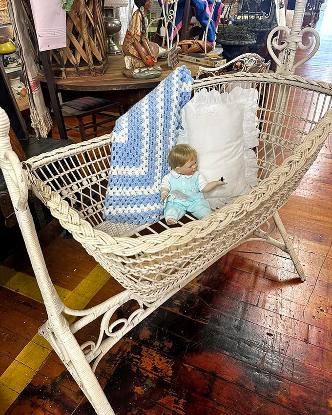 A wicker baby cradle that's rocked generations to sleep now waits for its next chapter&mdash;complete with vintage doll that's either adorable or the start of a horror movie.
