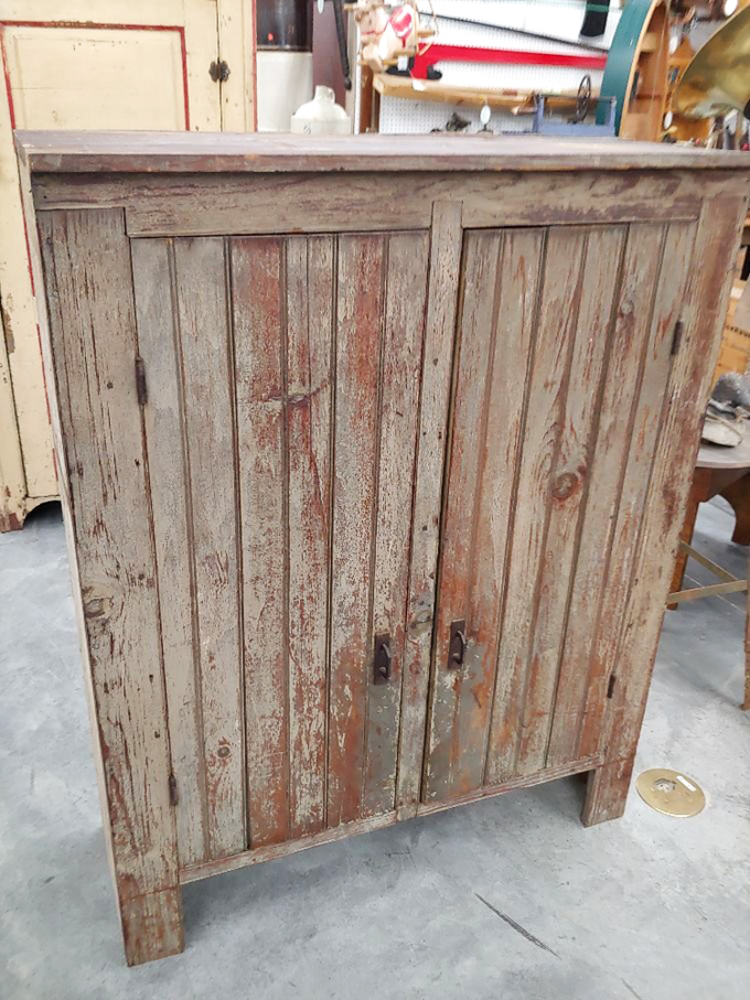 This weathered cupboard has more character in its peeling paint than most modern furniture acquires in a lifetime. Rustic chic before it was a hashtag.