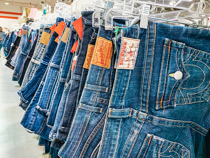 The denim rainbow—where your next favorite jeans hang patiently, already broken in by someone who clearly knew how to live.