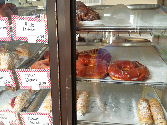 Apple fritters and glazed donuts sitting pretty behind glass, practically begging you to take them home immediately.