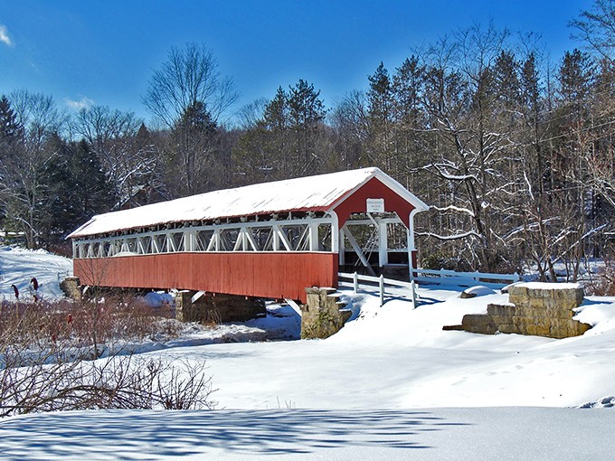 Snow blankets the landscape, highlighting the bridge's bold red against winter white. Even in freezing temperatures, this sight warms the soul.