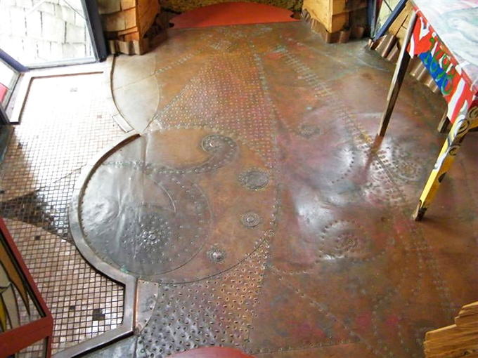 The floor becomes a canvas where copper and tile create patterns that shift with every step.