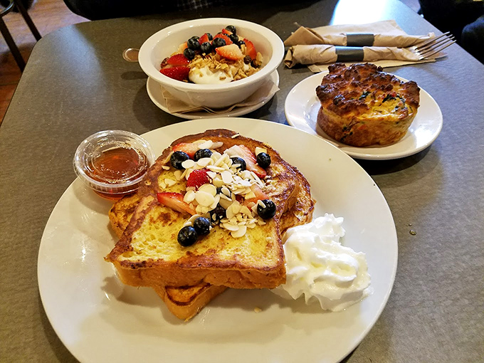 French toast that looks like it graduated from breakfast academy with honors &ndash; those berries and whipped cream aren't just toppings, they're the crown jewels.