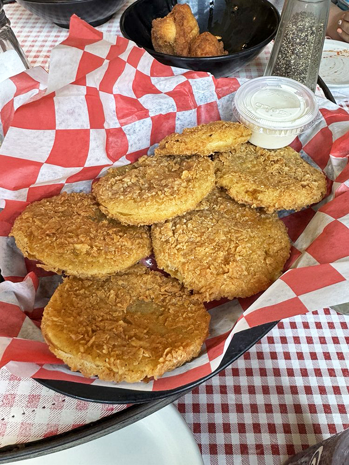 These fried green tomatoes deserve their own diploma—crispy, cornmeal-crusted discs of tangy perfection served with creamy dipping sauce.