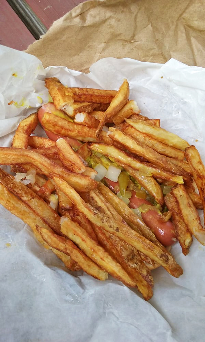 The golden cascade of fresh-cut fries transforms a hot dog into edible sculpture.
