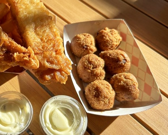 Hush puppies so perfectly golden they should come with a warning: "May cause involuntary food noises." Cornmeal orbs of pure comfort.