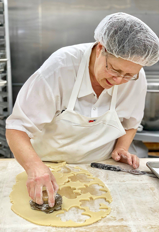 Hands that have shaped thousands of donuts work their magic, cutting perfect circles from dough that will soon become breakfast legends.
