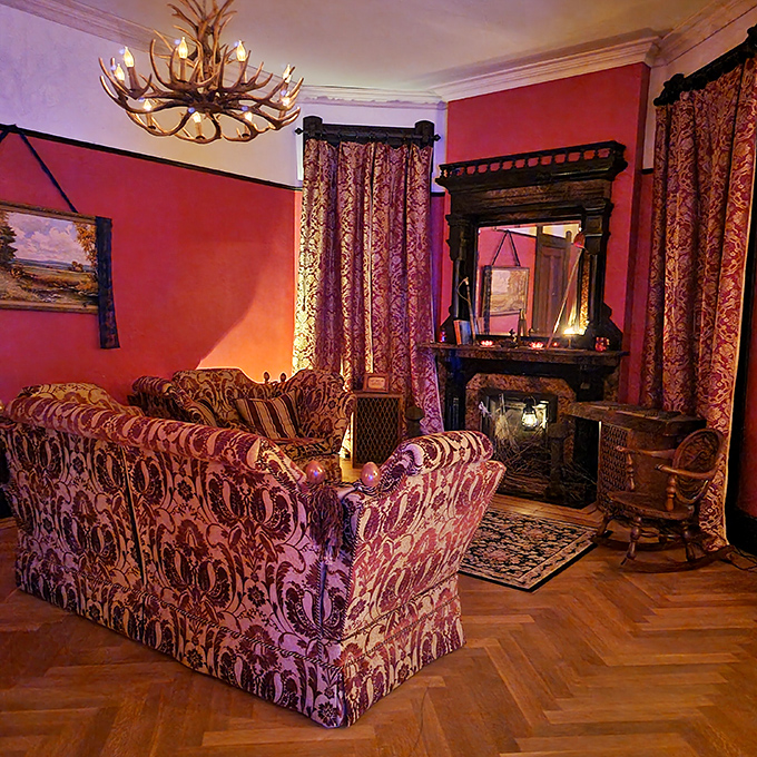 The crimson walls and antler chandelier create a parlor that's equal parts Victorian elegance and "The Shining." Perfect for entertaining both the living and departed.
