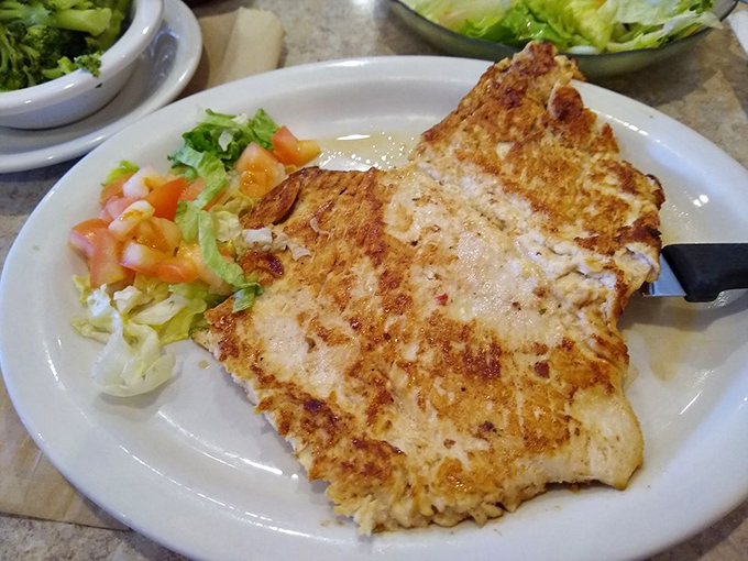 The legendary marinated chicken breast arrives perfectly caramelized, proving that sometimes the most unassuming dishes deliver the most profound satisfaction.