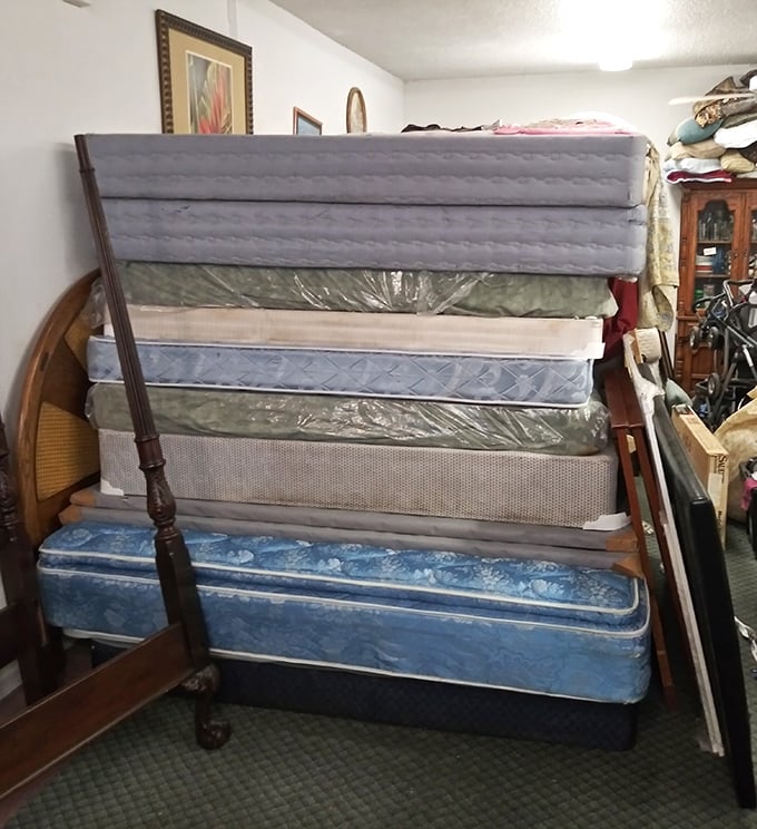 The leaning tower of mattresses stands as a monument to good nights' sleep past and future. Someone's dream bed awaits in this plush, slightly precarious stack.