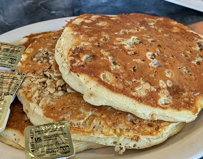 These pancakes tower like fluffy skyscrapers, defying gravity and redefining what breakfast excellence truly means.