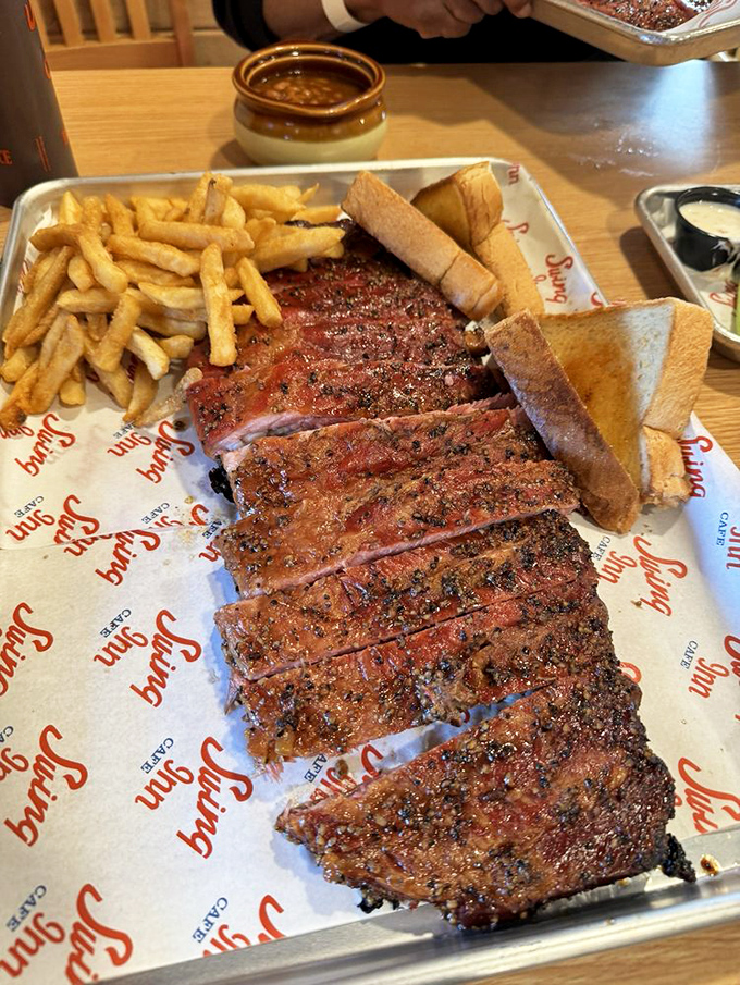 BBQ ribs sliced with surgical precision, sporting a bark so perfect it deserves its own trophy. That smoke ring is basically edible art.