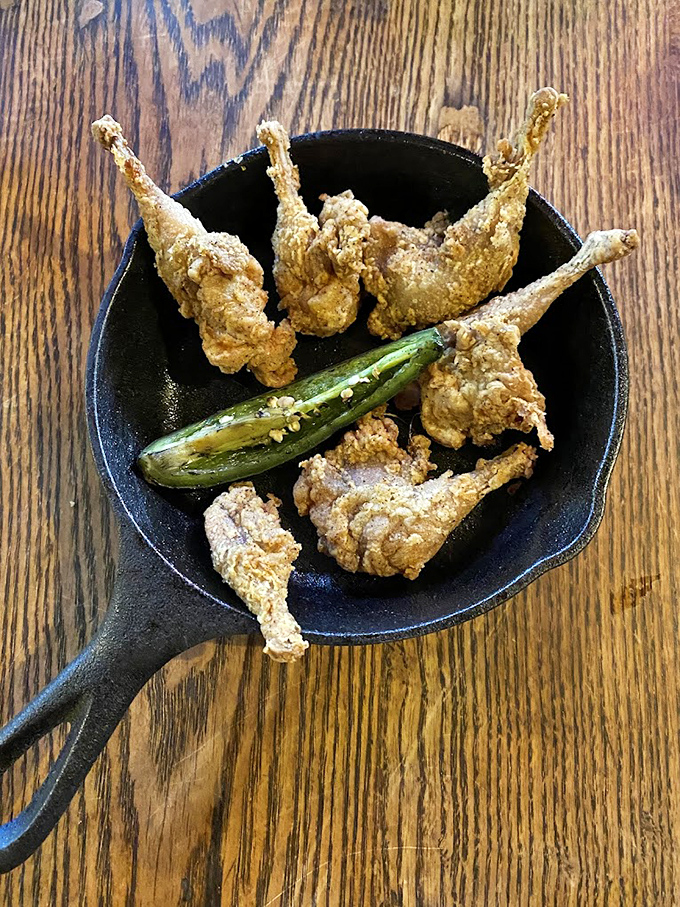 The legendary quail legs! Crispy, golden, and served with a jalapeño – they're like chicken wings that went to finishing school.