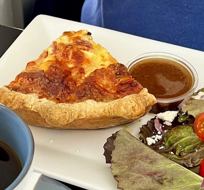 This quiche doesn't just sit there looking pretty—it puffs its pastry chest proudly, golden and confident, with a side salad for moral support.