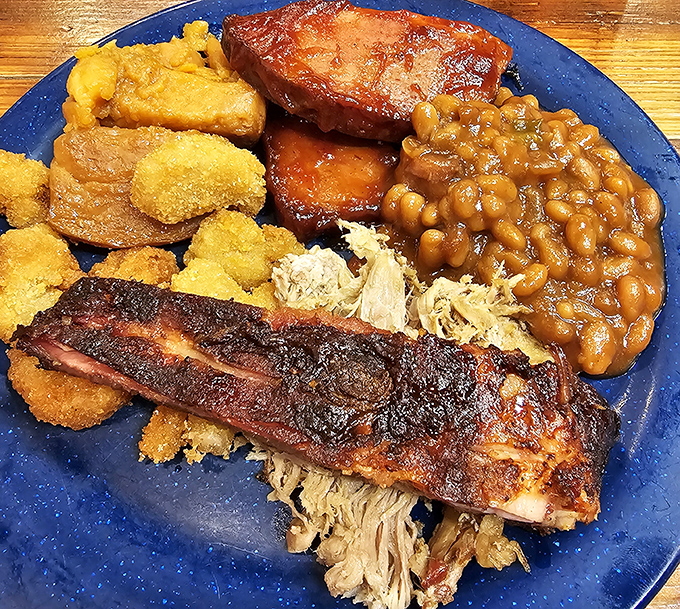 This isn't just a meal; it's edible architecture &ndash; layers of smoky ribs, pulled meat, and sides stacked like a delicious Southern skyscraper.