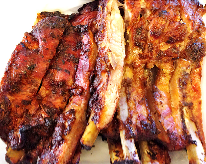 These ribs showcase that perfect pink smoke ring&mdash;the barbecue equivalent of a designer label. The bark has more character than most Hollywood scripts.