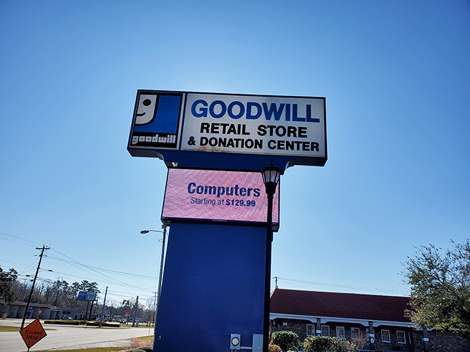 The iconic Goodwill smile logo welcomes bargain hunters from the roadside. That digital sign advertising computers? The modern equivalent of a dinner bell.