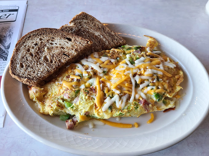 This omelet arrived ready for its close-up, dressed to the nines in melted cheese and fresh vegetables.