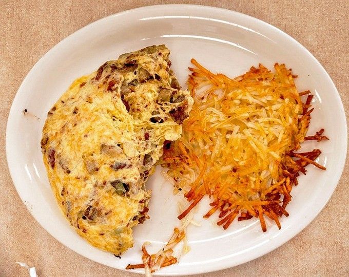 This sausage omelet with crispy hashbrowns represents breakfast perfection on a single satisfying plate.