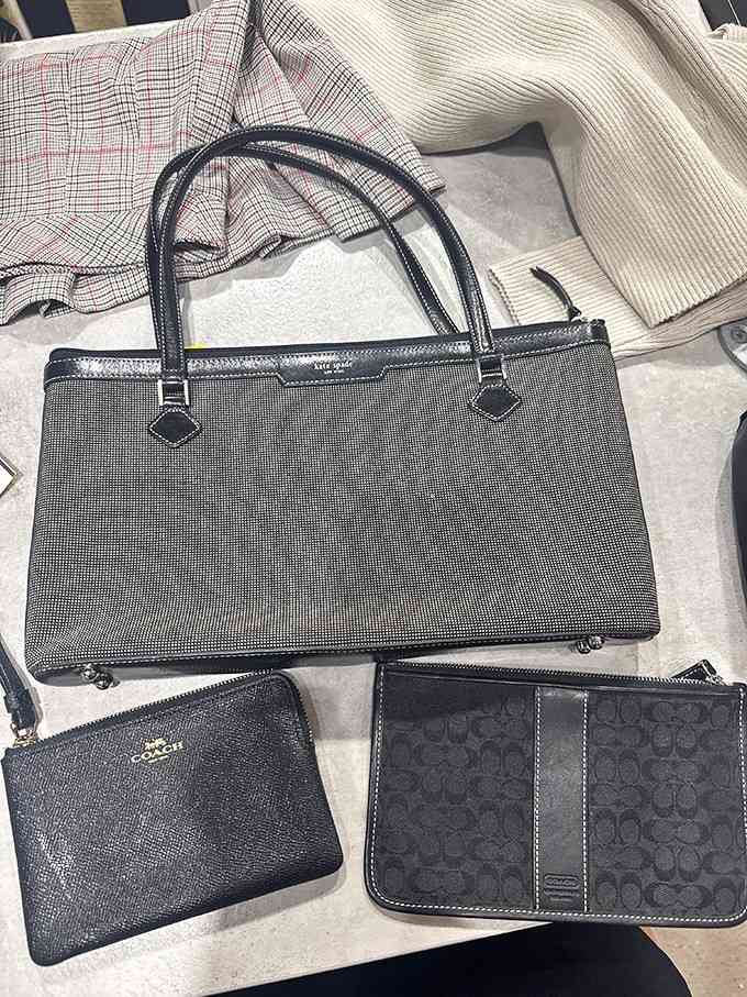 Designer bags and wallets lined up like luxury items at bargain basement dreams.