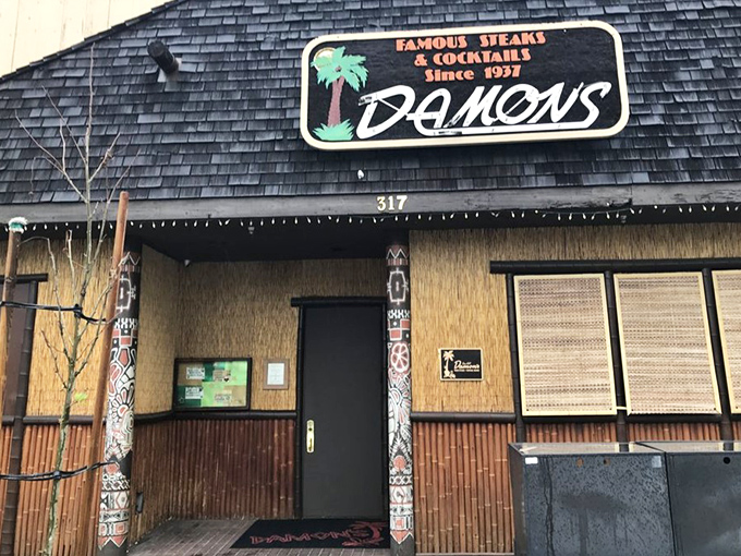 That retro bamboo exterior and palm tree promise a unique steakhouse experience where Polynesian flair meets perfectly grilled American beef.