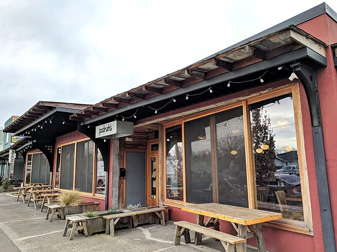 Podnah's modern exterior with rustic wooden benches creates the perfect prelude to the smoky symphony waiting inside.