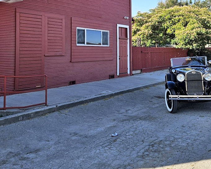 The Hitching Post's vintage red exterior and classic car create a time capsule of California BBQ history.