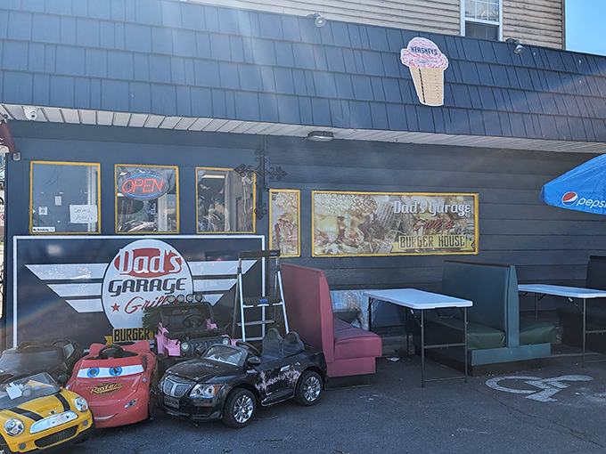 The vintage-inspired sign and toy cars create a nostalgic playground where burgers are the main attraction.