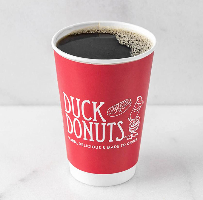 A proper cup of coffee in that signature red cup &ndash; because every great donut deserves a worthy companion. It's the Fred to your Ginger.