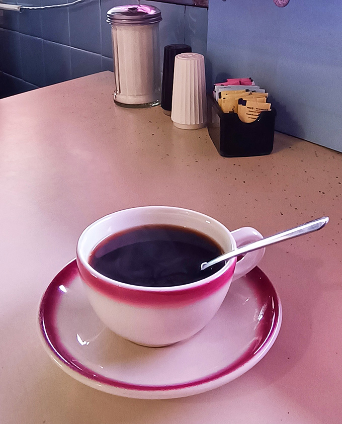 The coffee comes in that perfect pink-rimmed mug that somehow makes it taste better&mdash;diner science that no laboratory could ever replicate.