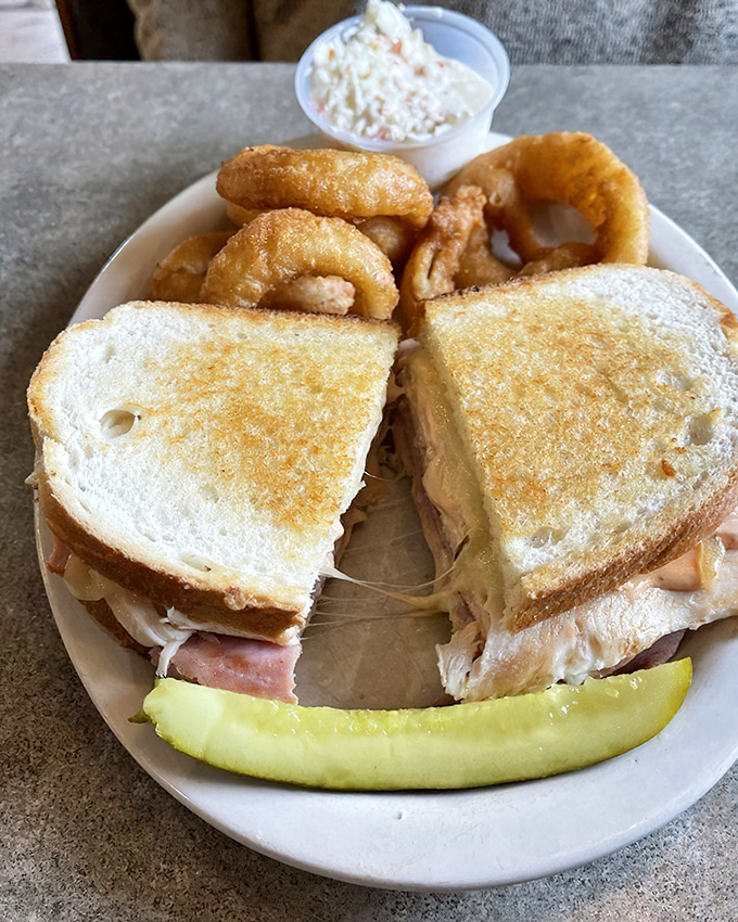 A sandwich built like a heavyweight champion&mdash;layers of meat and cheese creating the perfect lunch companion. That pickle spear isn't just garnish, it's necessary balance.