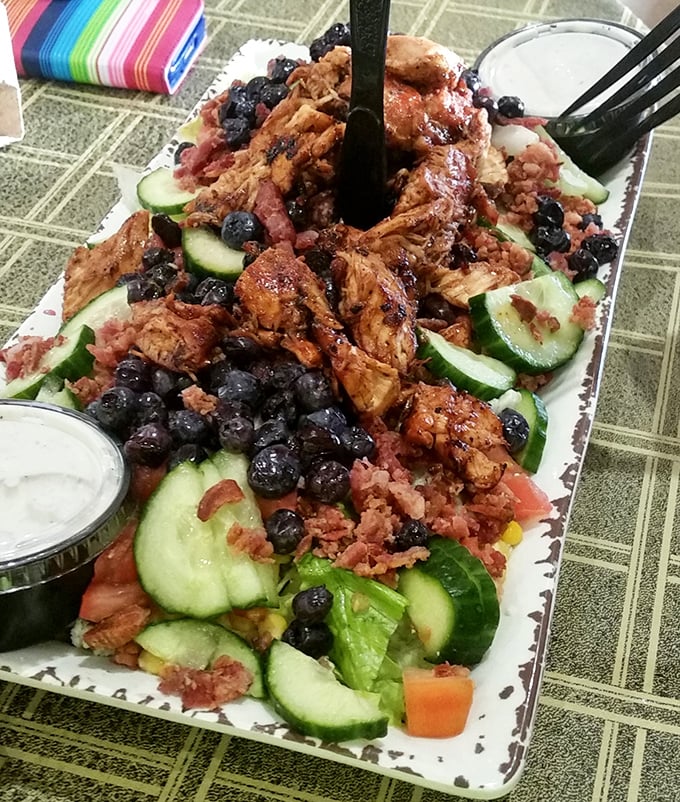Fresh salad topped with smoky chicken, proving barbecue joints can do healthy without sacrificing any flavor.