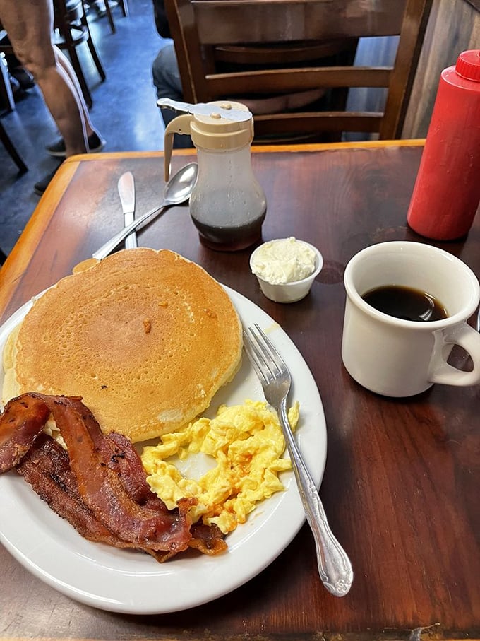 Classic diner breakfast executed flawlessly&mdash;crispy bacon, fluffy eggs, and a pancake that could double as a pillow. Comfort on a plate.